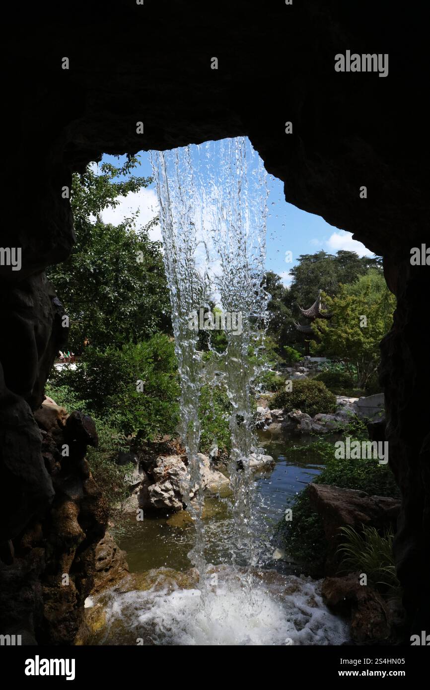 Standing behind a waterfall, looking through the water at a Chinese ...