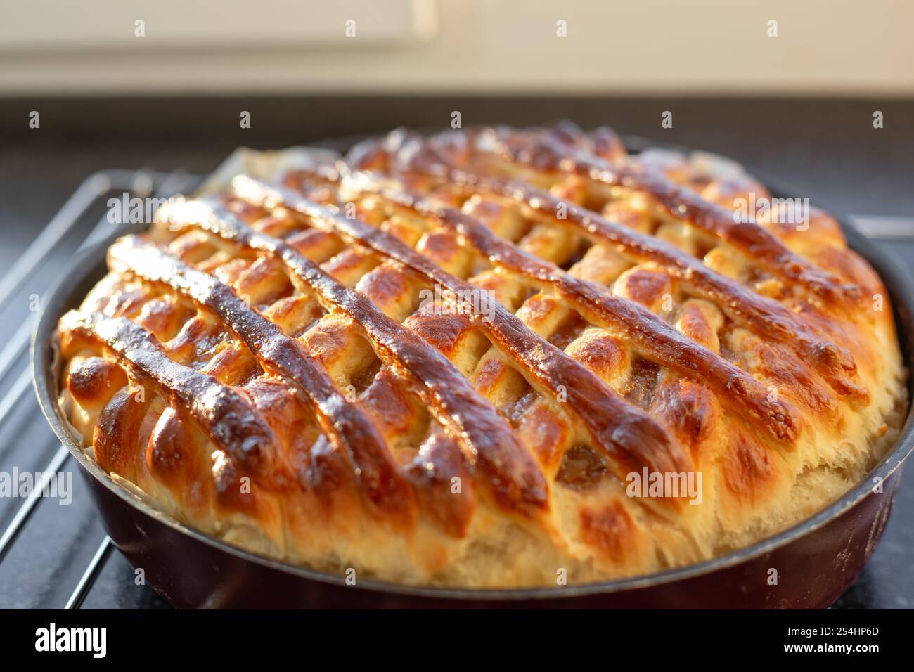 A rich pie with jam, the top crust is made of woven dough in the form ...