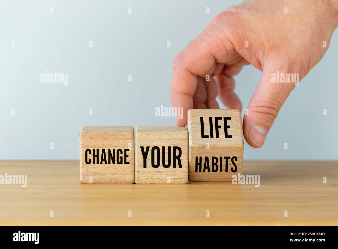 Hand turns wooden block and changes the words Change your habits to ...