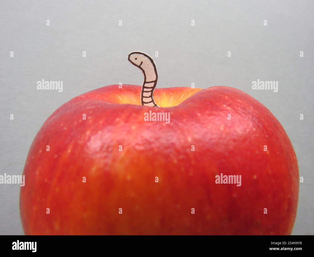 Red Apple With A Comic-style Worm Peeking Out Of It Stock Photo - Alamy