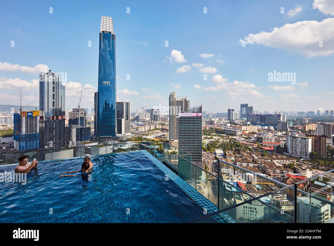 People take photos in the swimming pool on the rooftop of a high-rise ...