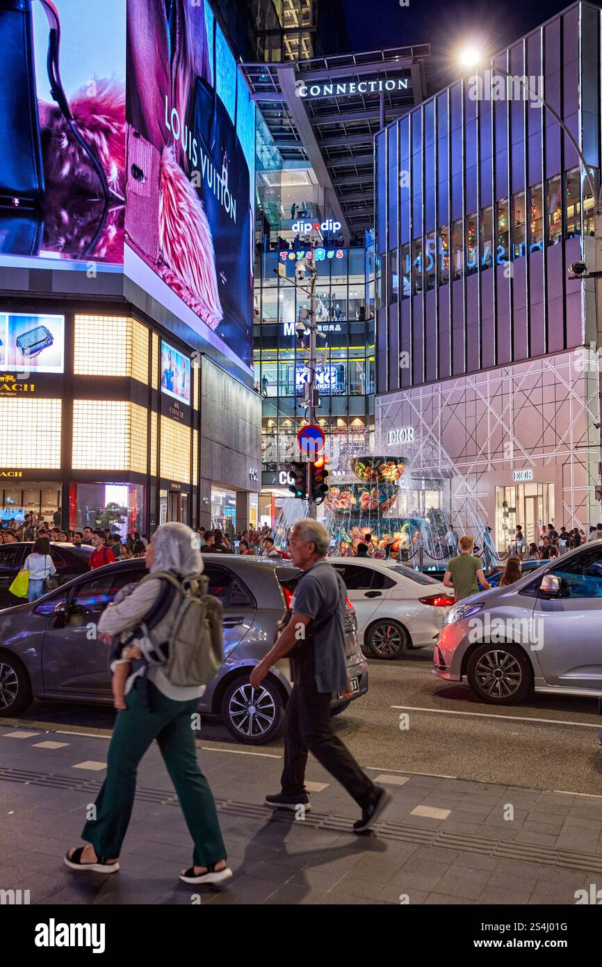People walk along Jalan Bukit Bintang in front of the Pavilion Shopping ...