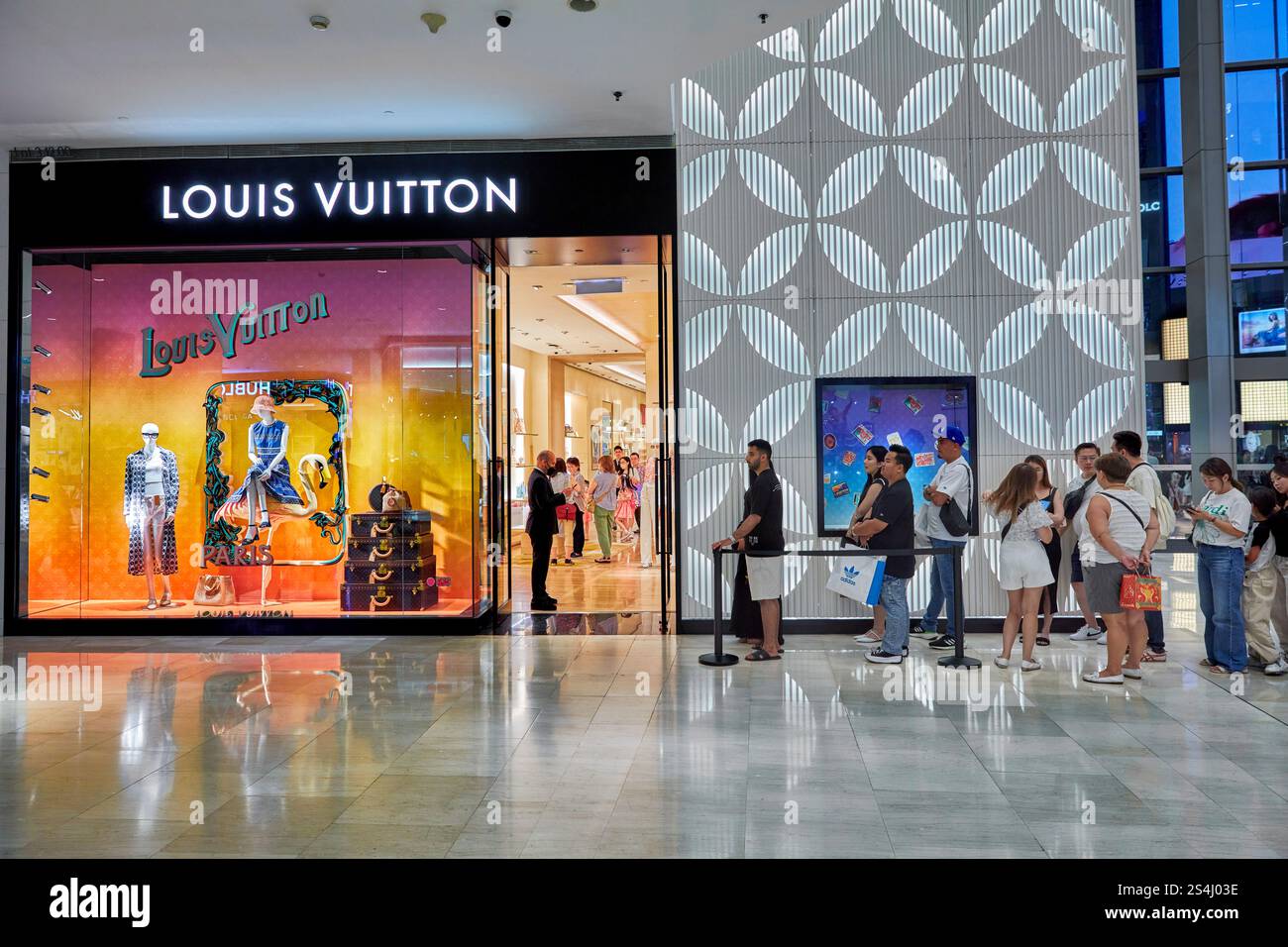 People wait in line to enter Louis Vuitton store in The Pavilion, an ...