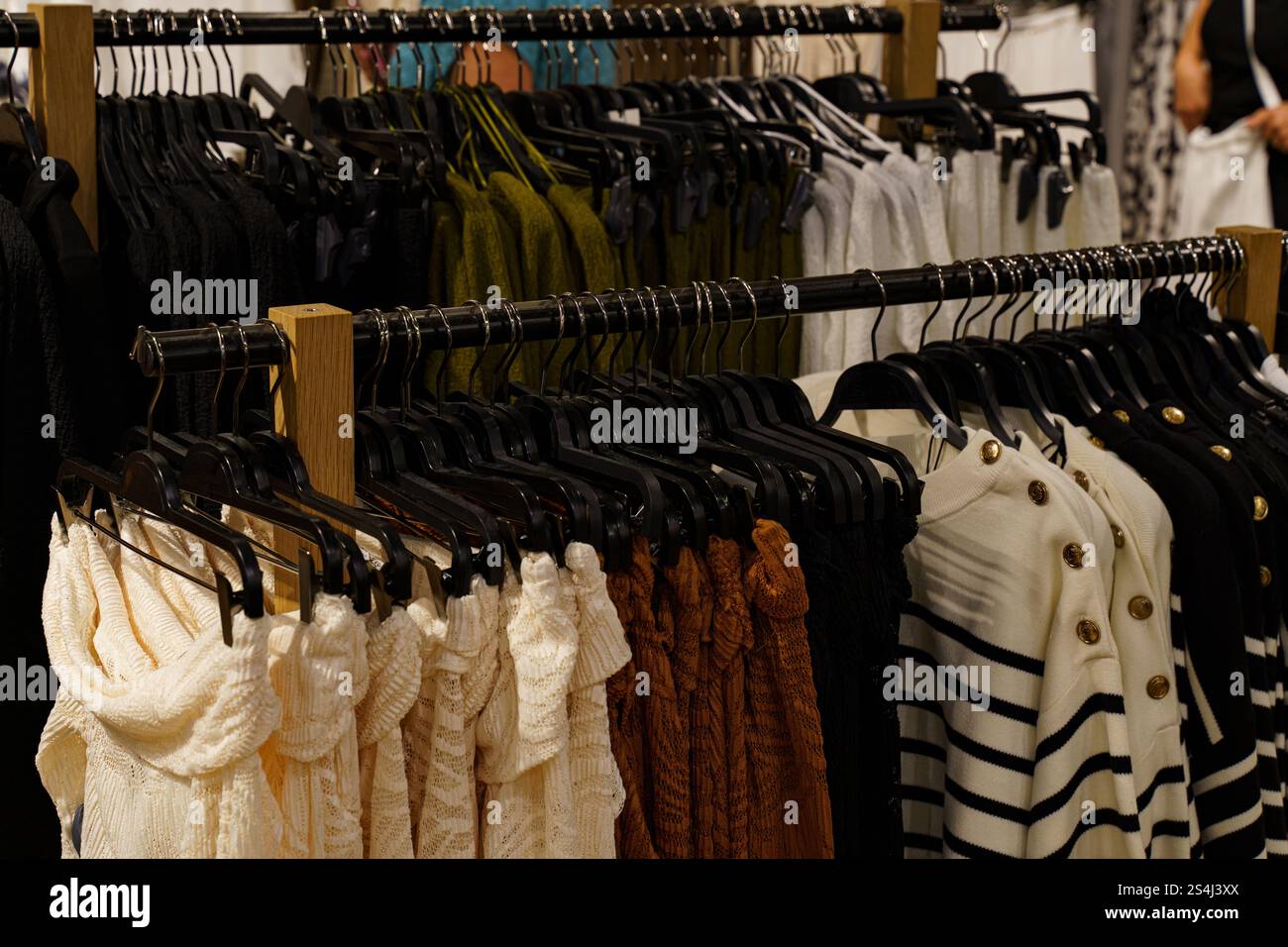Rows of stylish garments hang neatly on display in a modern clothing ...