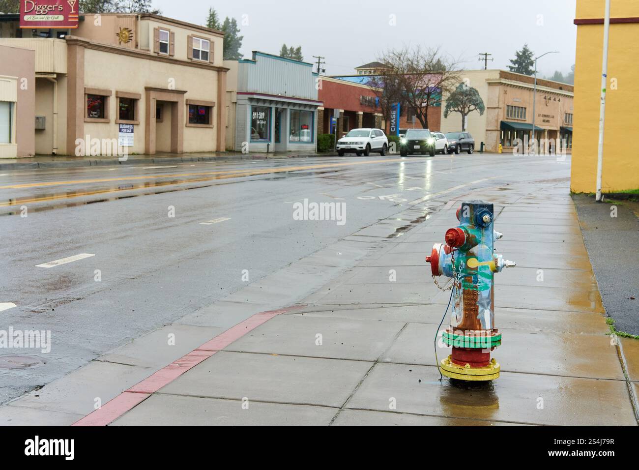 View along Main Street with an oncoming car and several storefronts ...