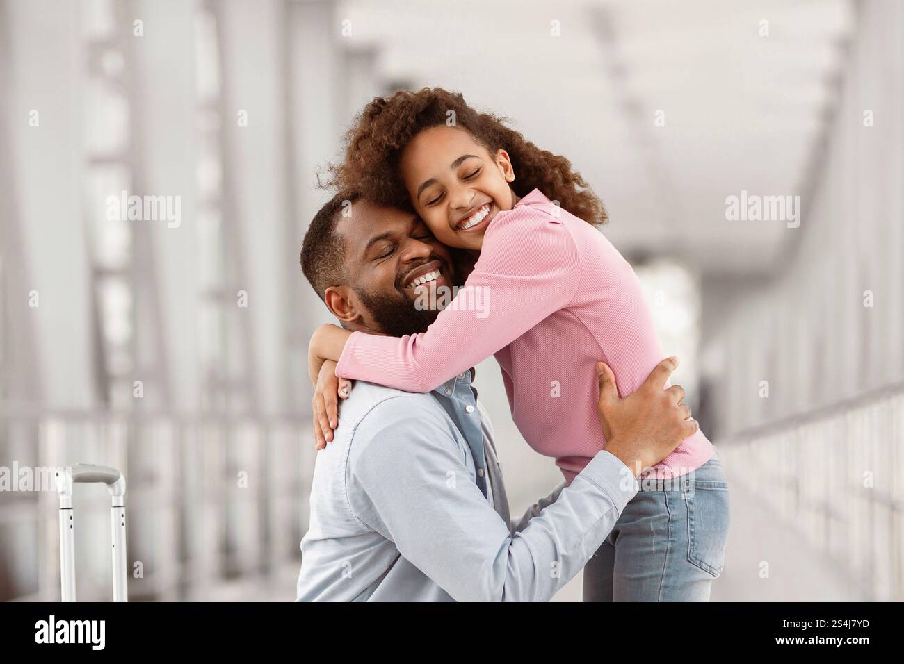 Happy black man hugging girl kid in airport Stock Photo - Alamy