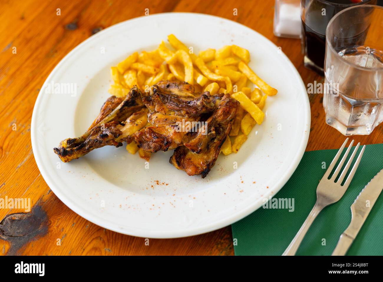 Baked rabbit leg with side dish of french fries Stock Photo - Alamy