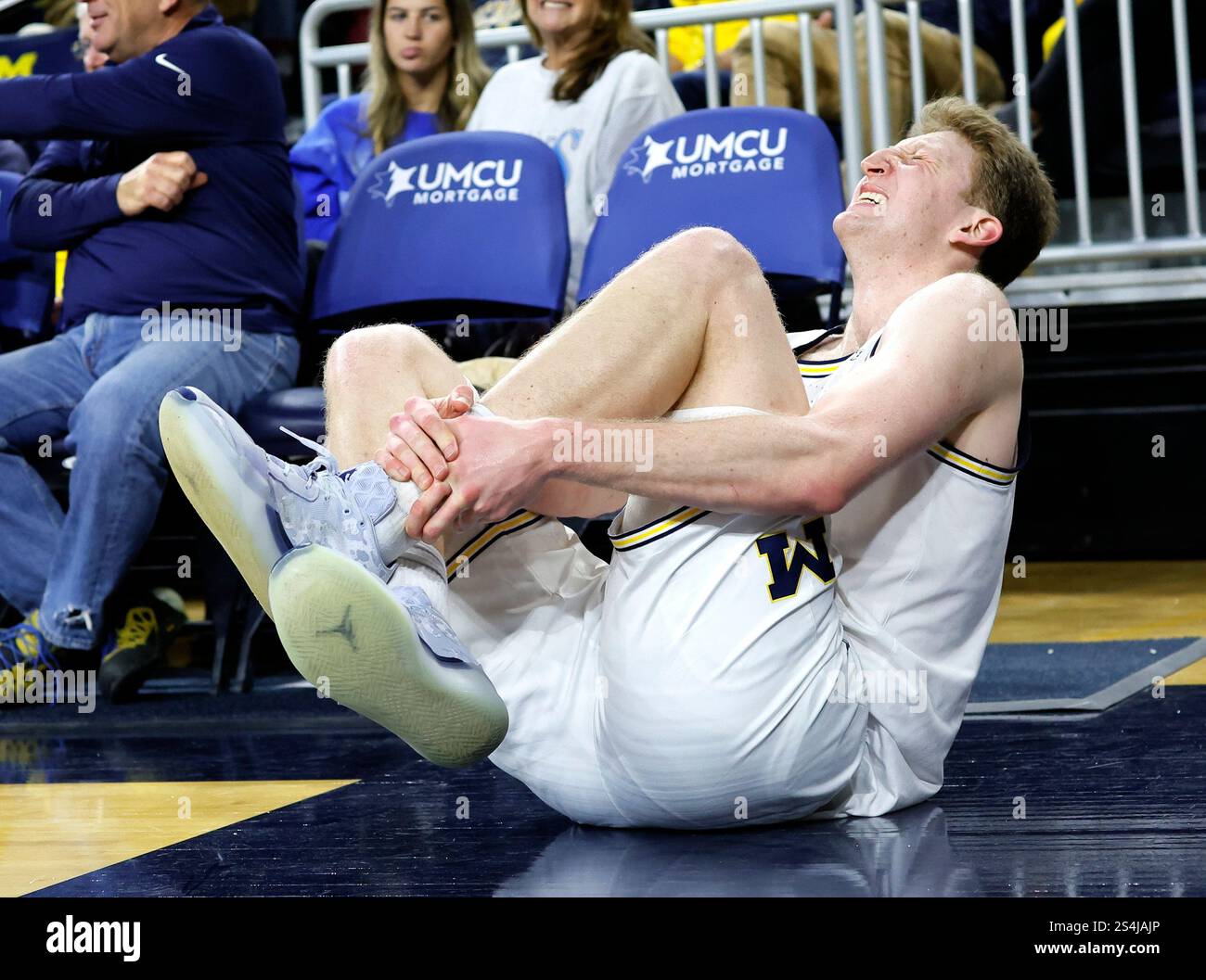 Michigan center Danny Wolf (1) grimaces and grabs his ankle during the ...