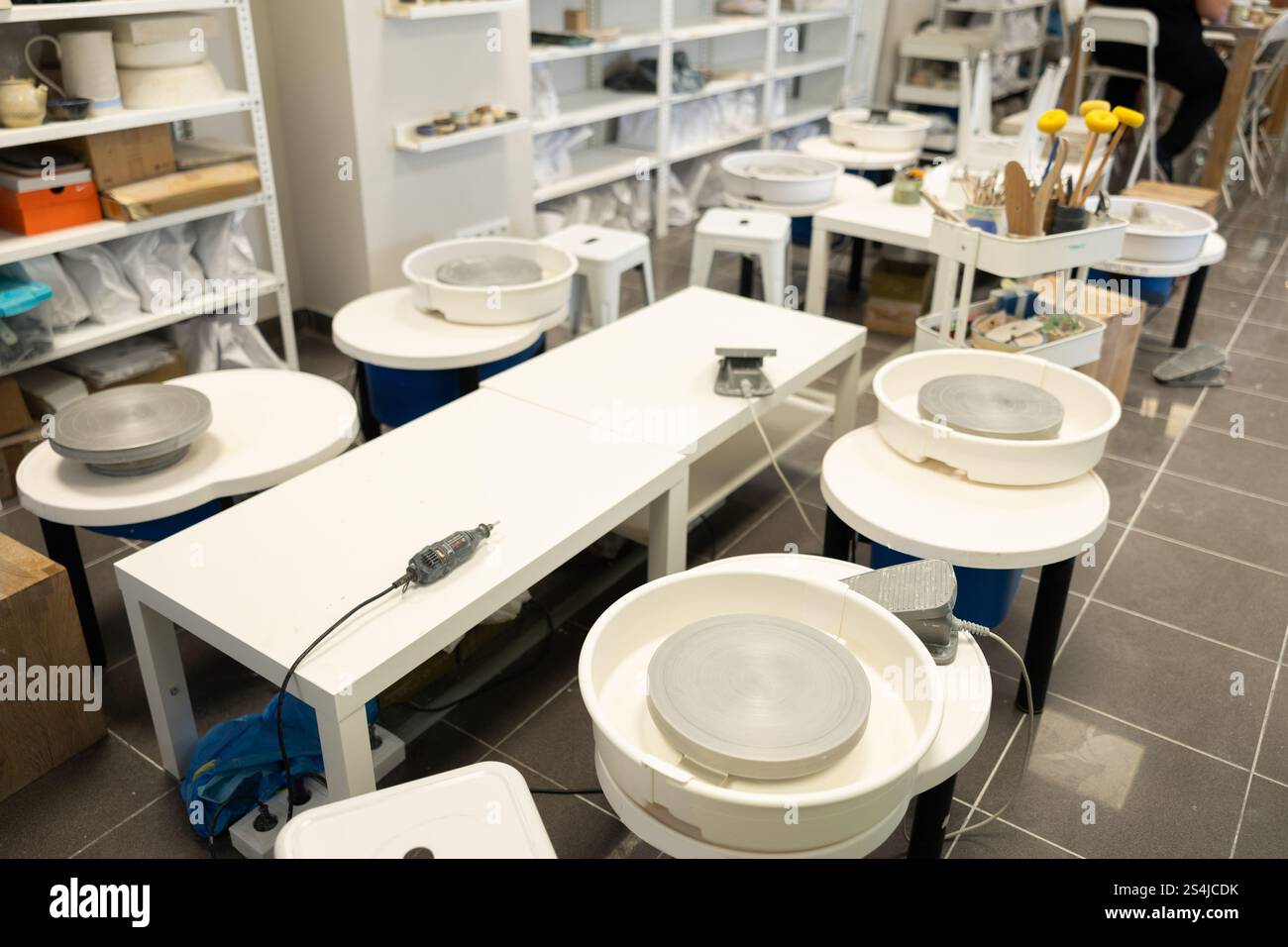 Pottery wheels and tables in ceramics workshop Stock Photo - Alamy