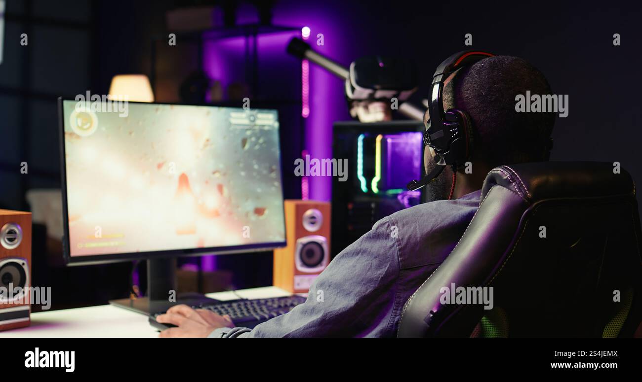 Pro gamer wearing headphones playing science fiction game. Content ...