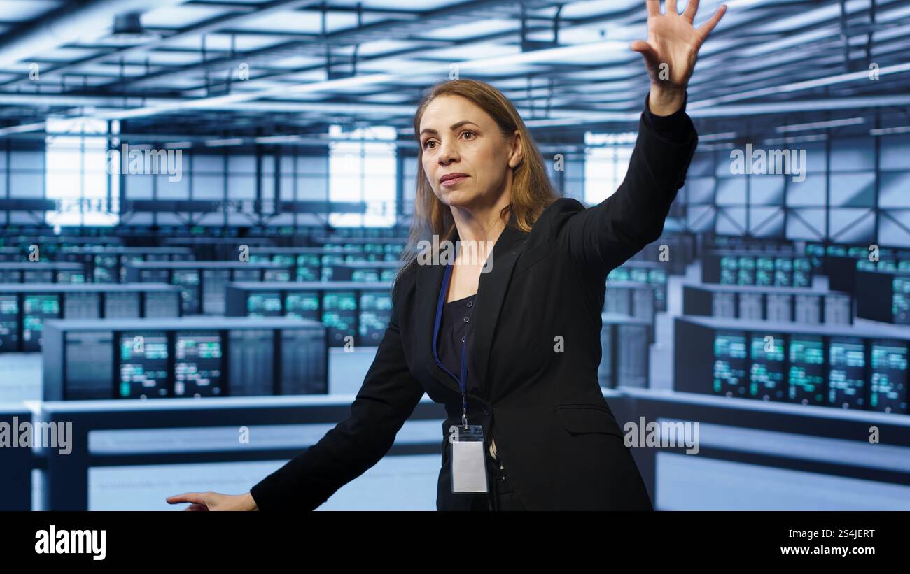 Software developer looking at holograms in data center, monitoring ...