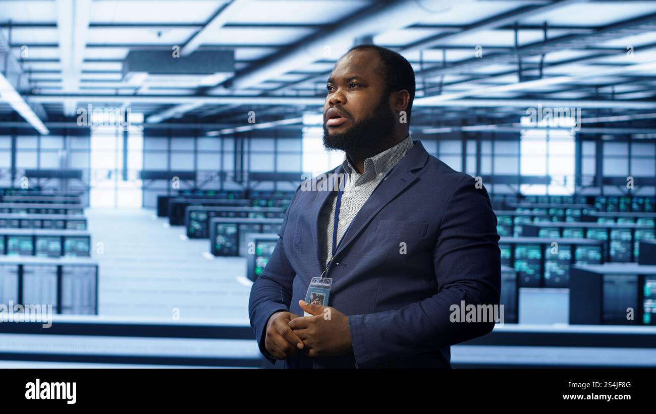 System administrator looking at holograms in data center, monitoring ...