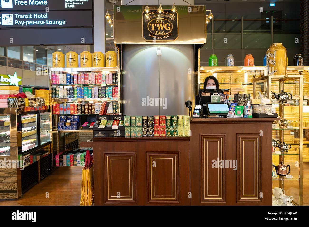 SINGAPORE - AUGUST 25, 2024: staff member behind the counter with ...