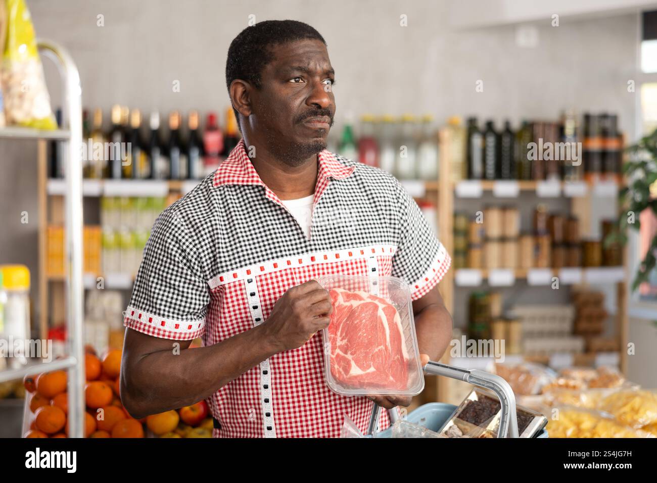 African man choose raw beef entrecote meat for roasting in store Stock ...