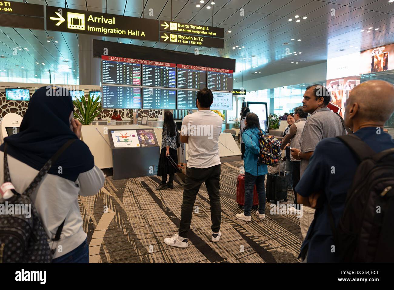 SINGAPORE - AUGUST 25, 2024: passengers at Changi Airport stand near ...