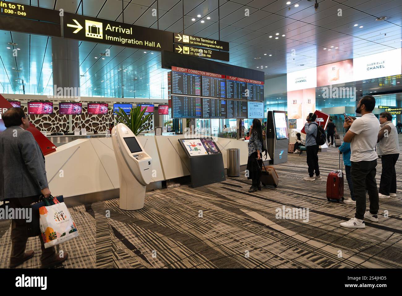 SINGAPORE - AUGUST 25, 2024: passengers at Changi Airport stand near ...