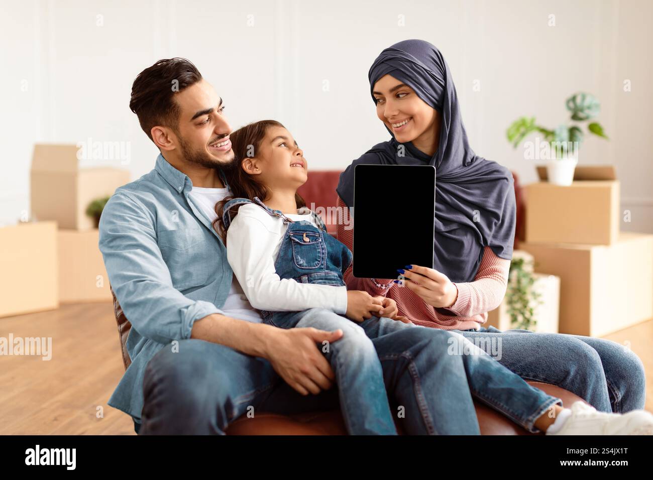 Happy muslim family doing repair woman showing tablet Stock Photo - Alamy