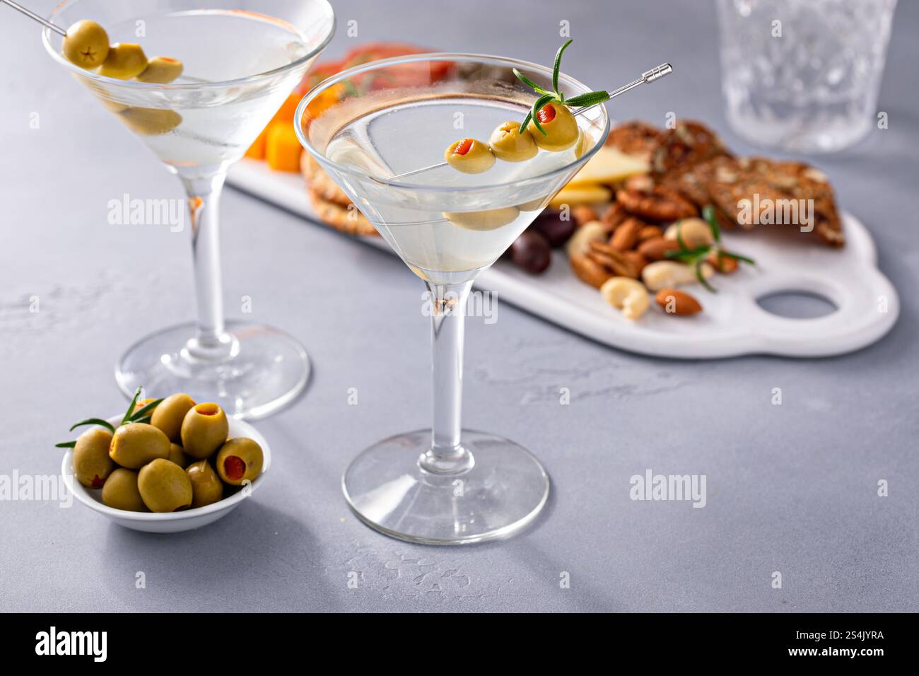 Traditional martini cocktail with olives garnish and charcuterie board ...