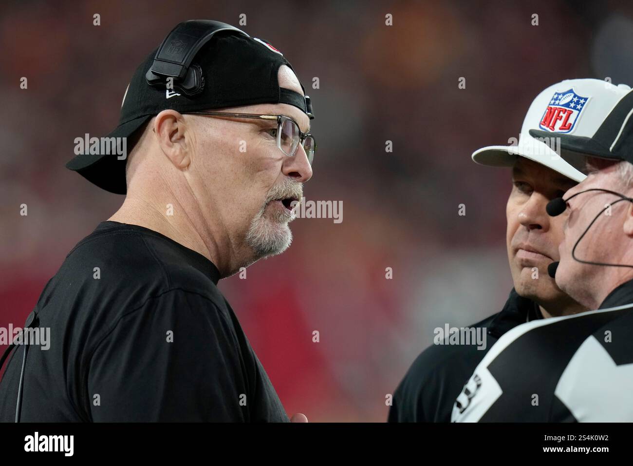 Washington Commanders head coach Dan Quinn, left, talks with officials ...