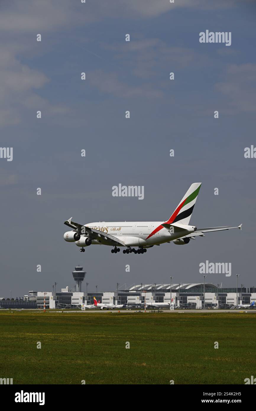 Emirates Airbus A380-800 approaching under blue sky, with control tower ...