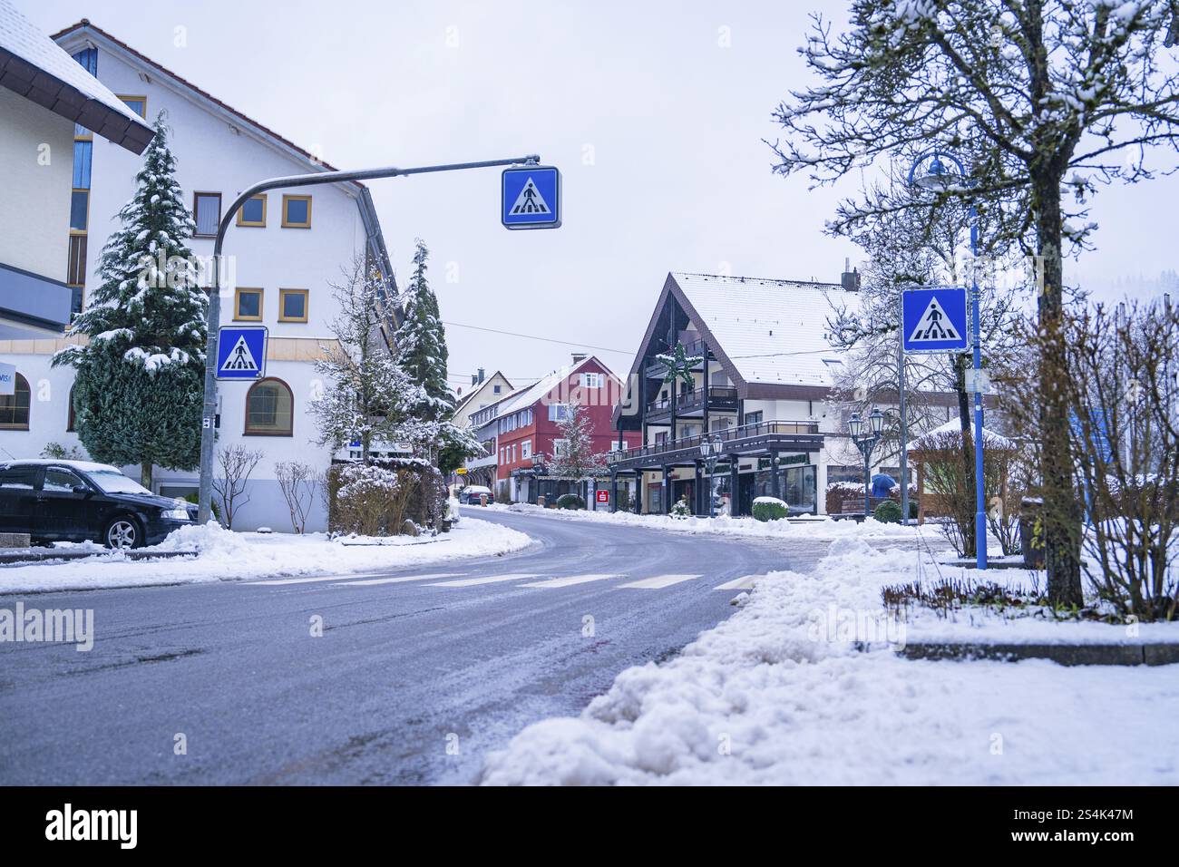 Snow-covered street in a village surrounded by traditional houses and ...