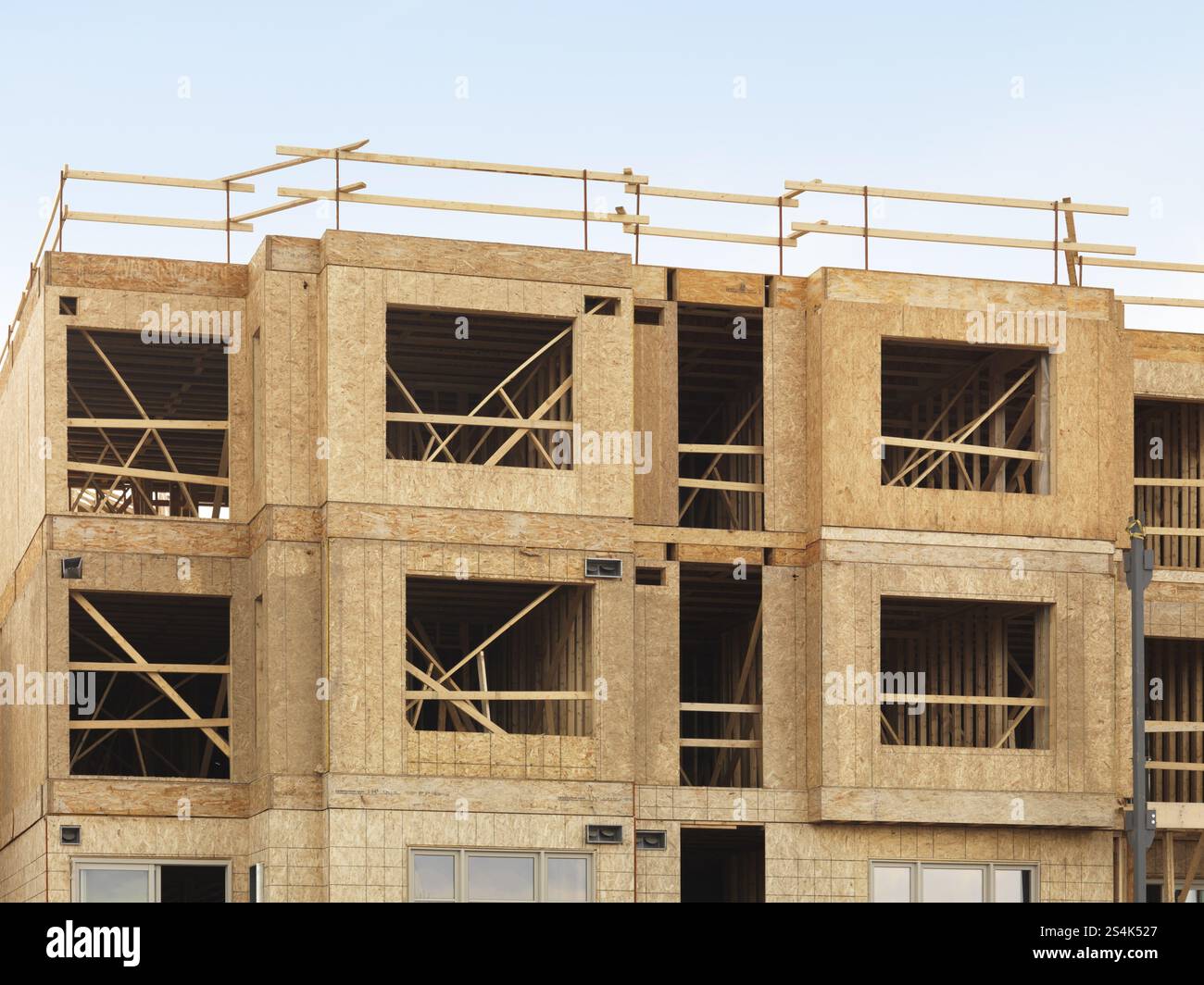 Wooden framing of a residential three story building under construction ...
