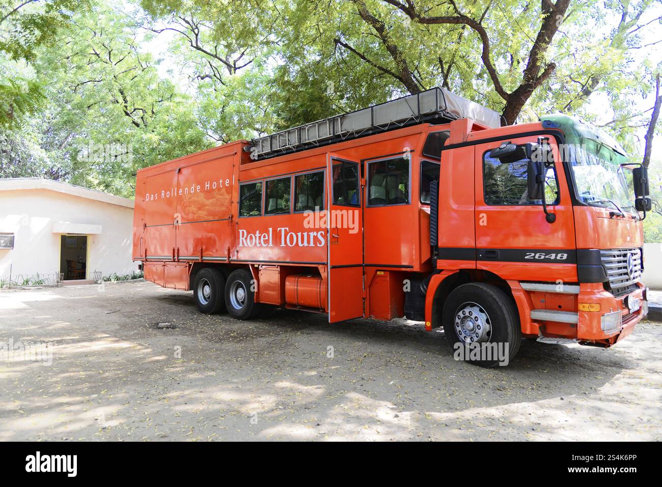 Madurai, South India, India, Asia, Big orange tour bus on a forested ...