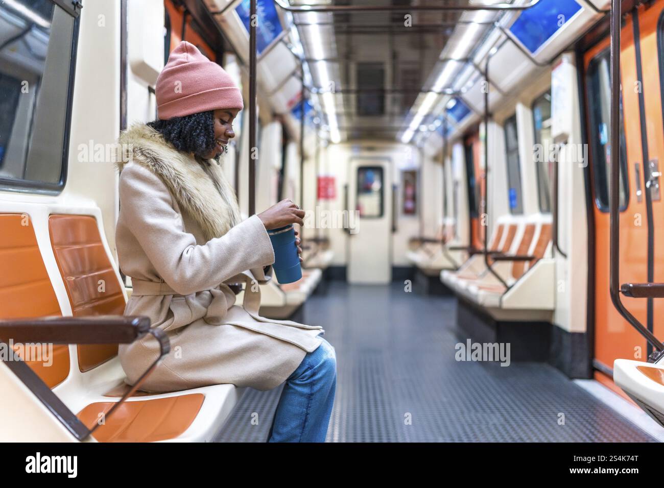 Passenger opening a reusable coffee cup while enjoying a quiet moment ...