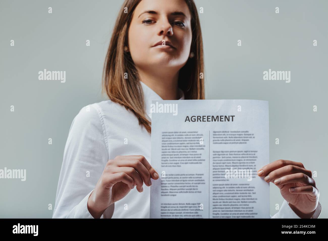 Businesswoman holding and displaying an agreement document toward the ...