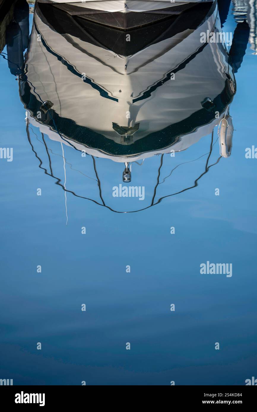 Boat reflection in blue water Stock Photo - Alamy