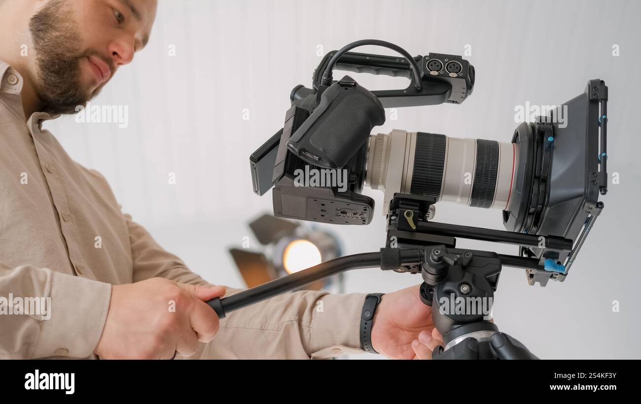 Cameraman work. Videographer production. Man adjusts professional ...