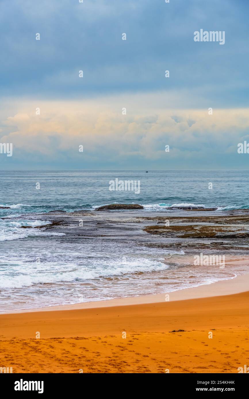 Mona Vale Beach in the daytime under a cloud covered Winter sky ...