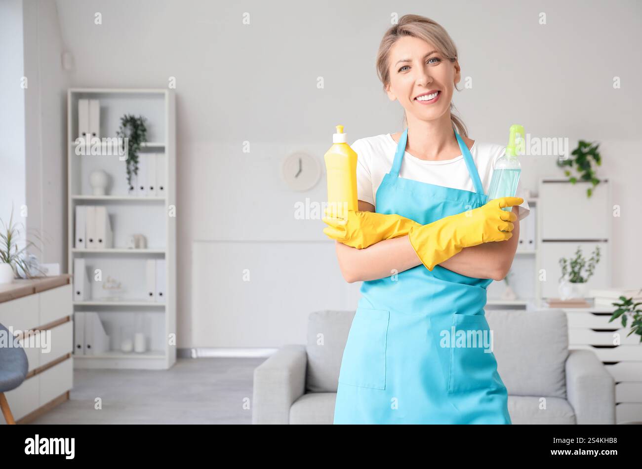 Female janitor with bottles of detergent in office Stock Photo - Alamy