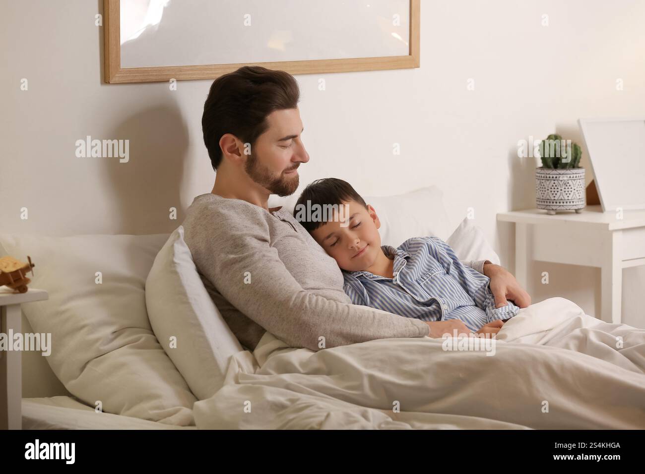 Cute little boy with his father sleeping in bedroom Stock Photo - Alamy