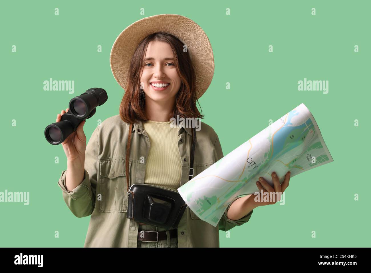 Female traveler with map and binoculars on green background. Itinerary ...