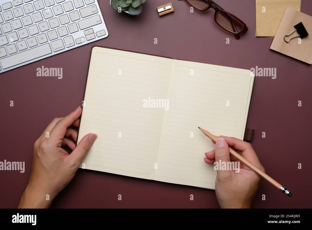 Aerial view of hands writing in an open notebook. Creativity, planning ...