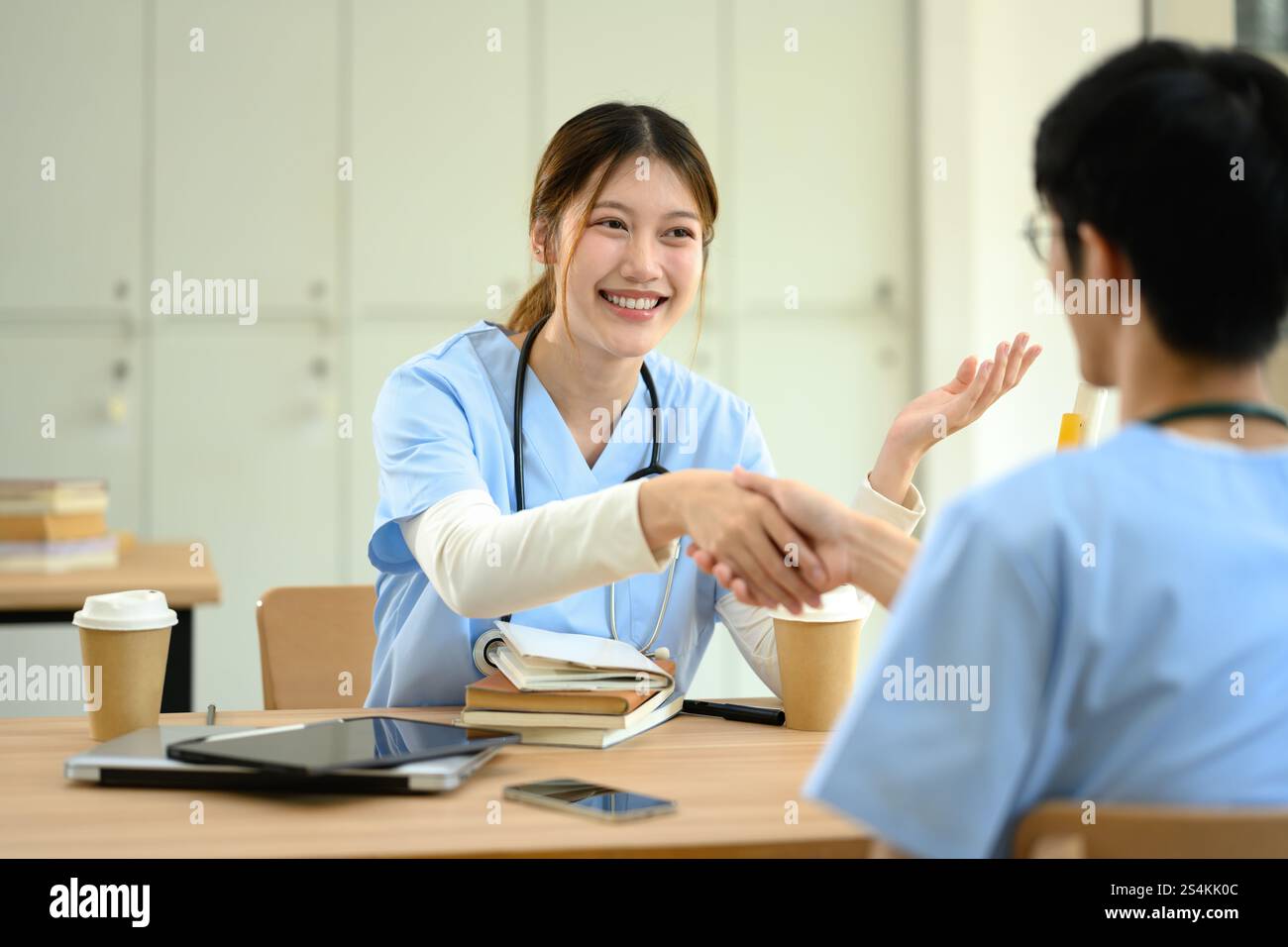 Two medical students shaking hands hi-res stock photography and images ...