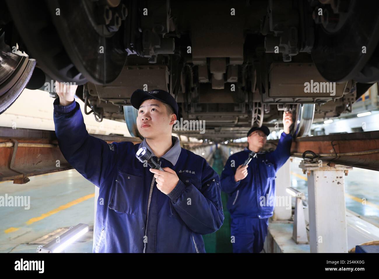 A ground service mechanic inspects an EMU train at the inspection depot ...