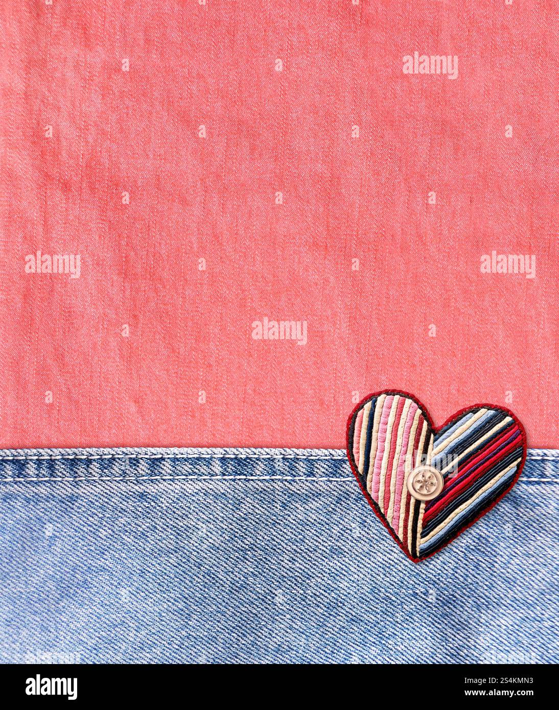 Light blue and coral color denim background with felt heart in ...