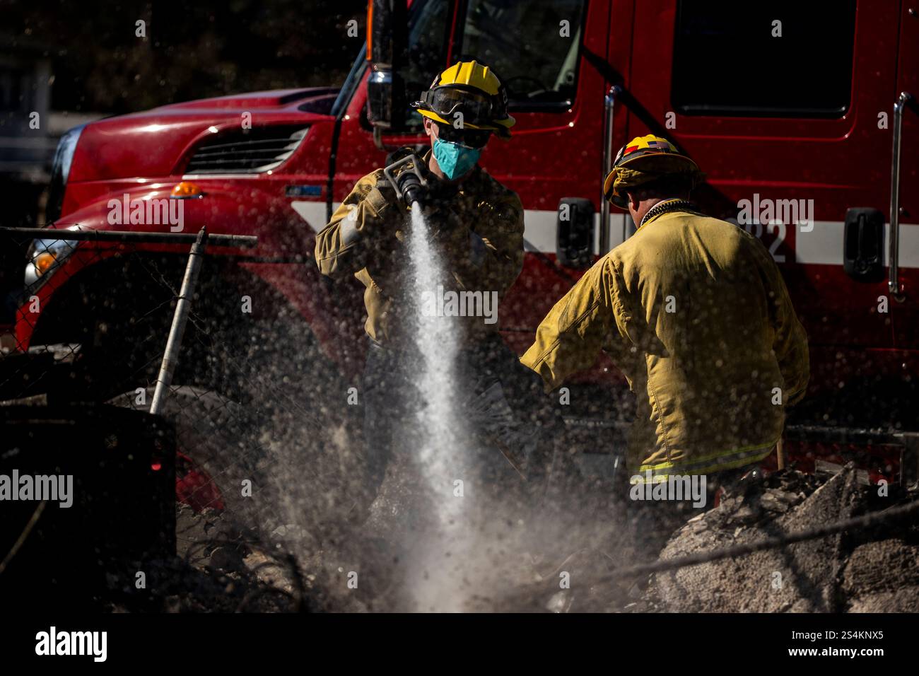 A Cal Fire engine crew with the Nevada-Yuba-Placer Unit hoses down a ...