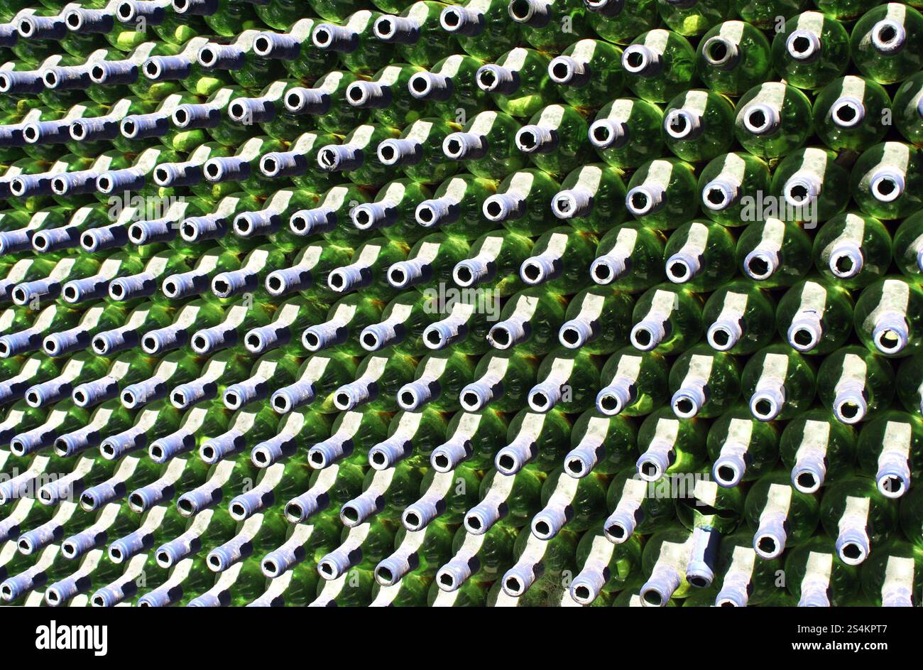Full frame wall with empty green beer bottles necks. Alcohol theme ...