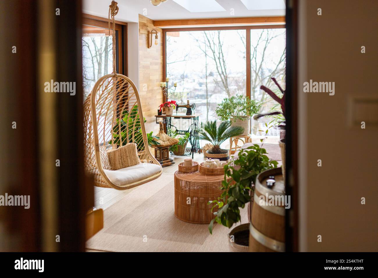 The interior of a modern, bright room with large windows and rattan ...