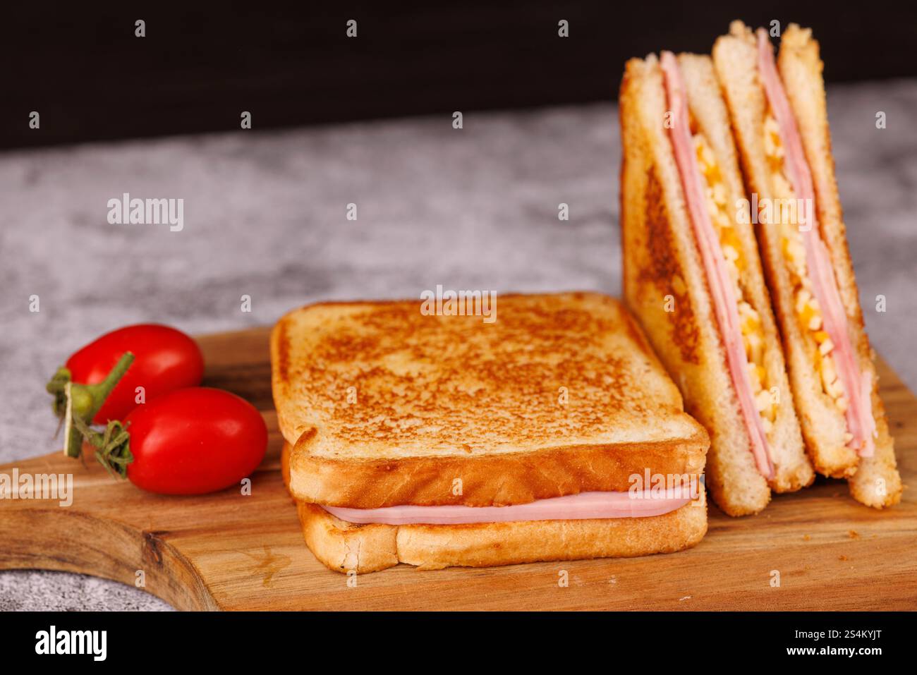 A mouthwatering display of ham and cheese sandwiches, cut in half and ...