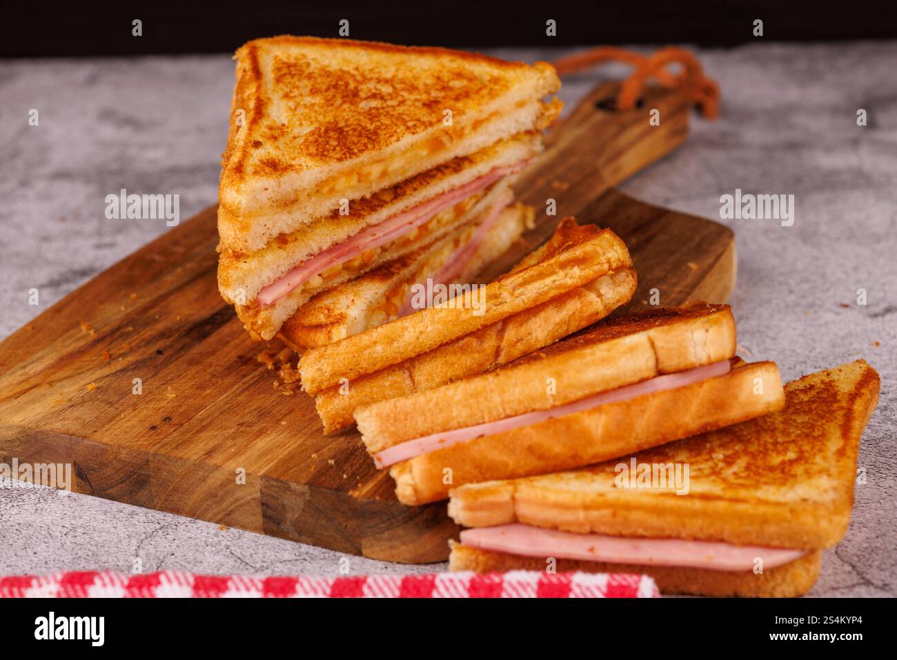 A tempting selection of ham and cheese sandwiches cut in half, stacked ...