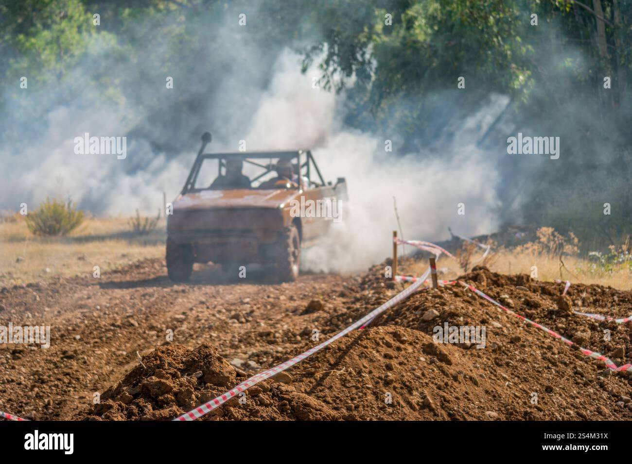 off-road race. A rugged vehicle, enveloped in a cloud of dust and smoke ...