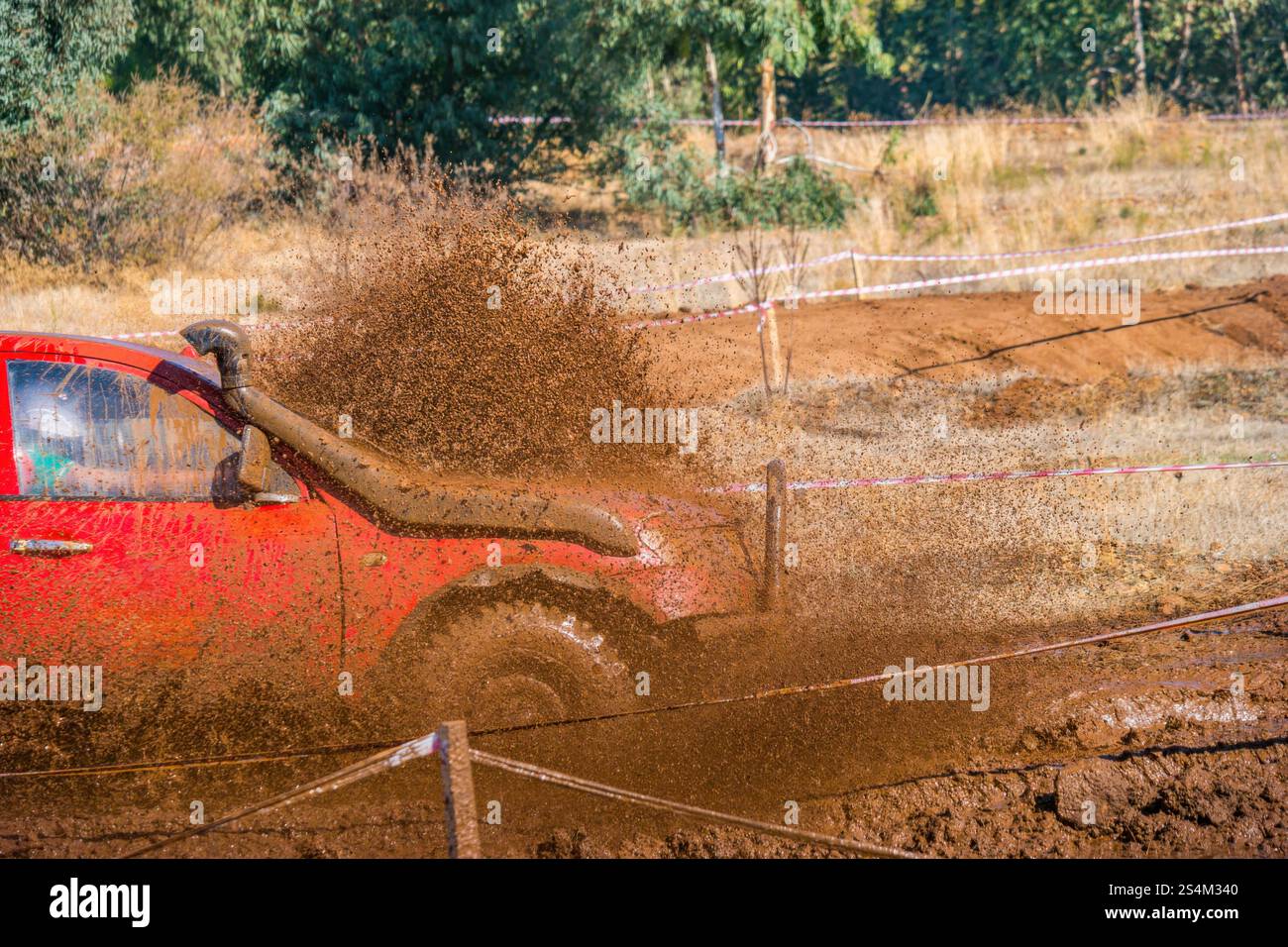 off-road vehicle plowing through a muddy track. The car's tires are ...