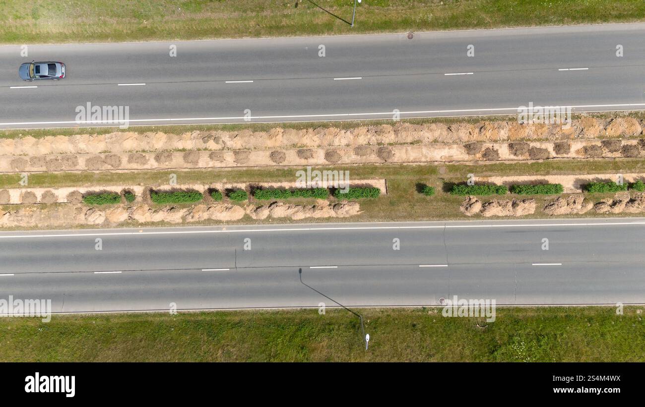 Aerial view of a divided highway with a car on one side and median ...