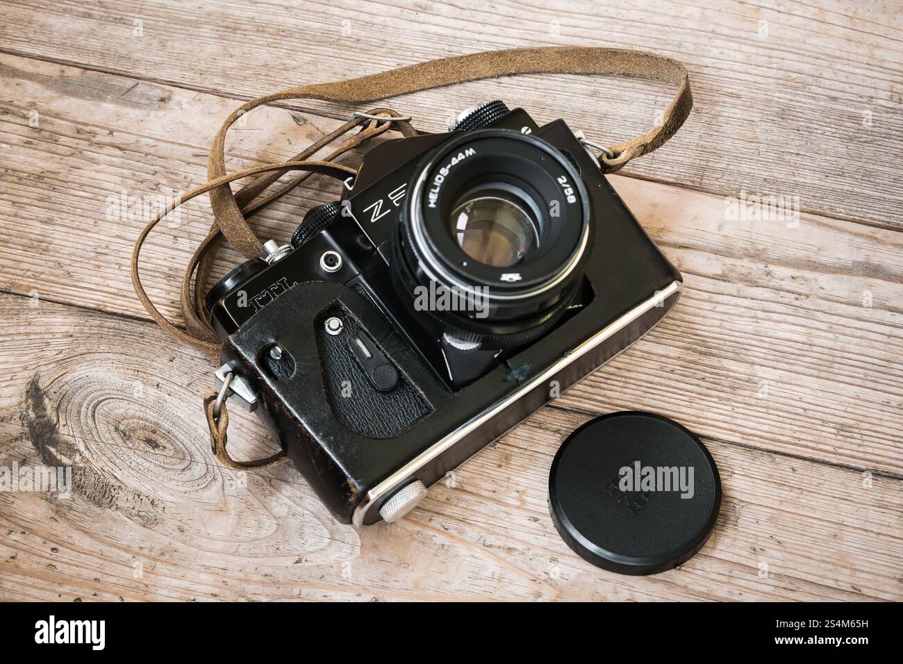 Black Soviet film camera ZENIT TTL in a leather case on a wooden ...