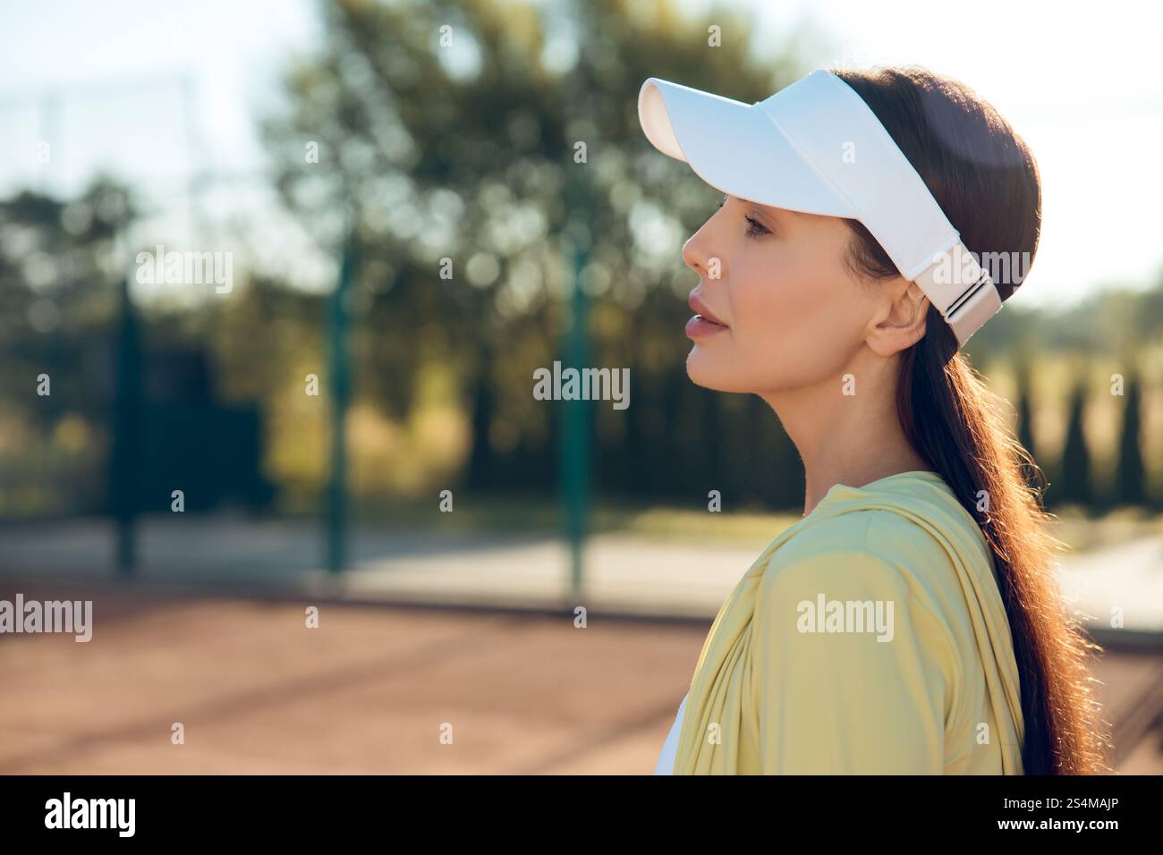 Cute female tennis player in white cap feeling happy and smiling Stock ...