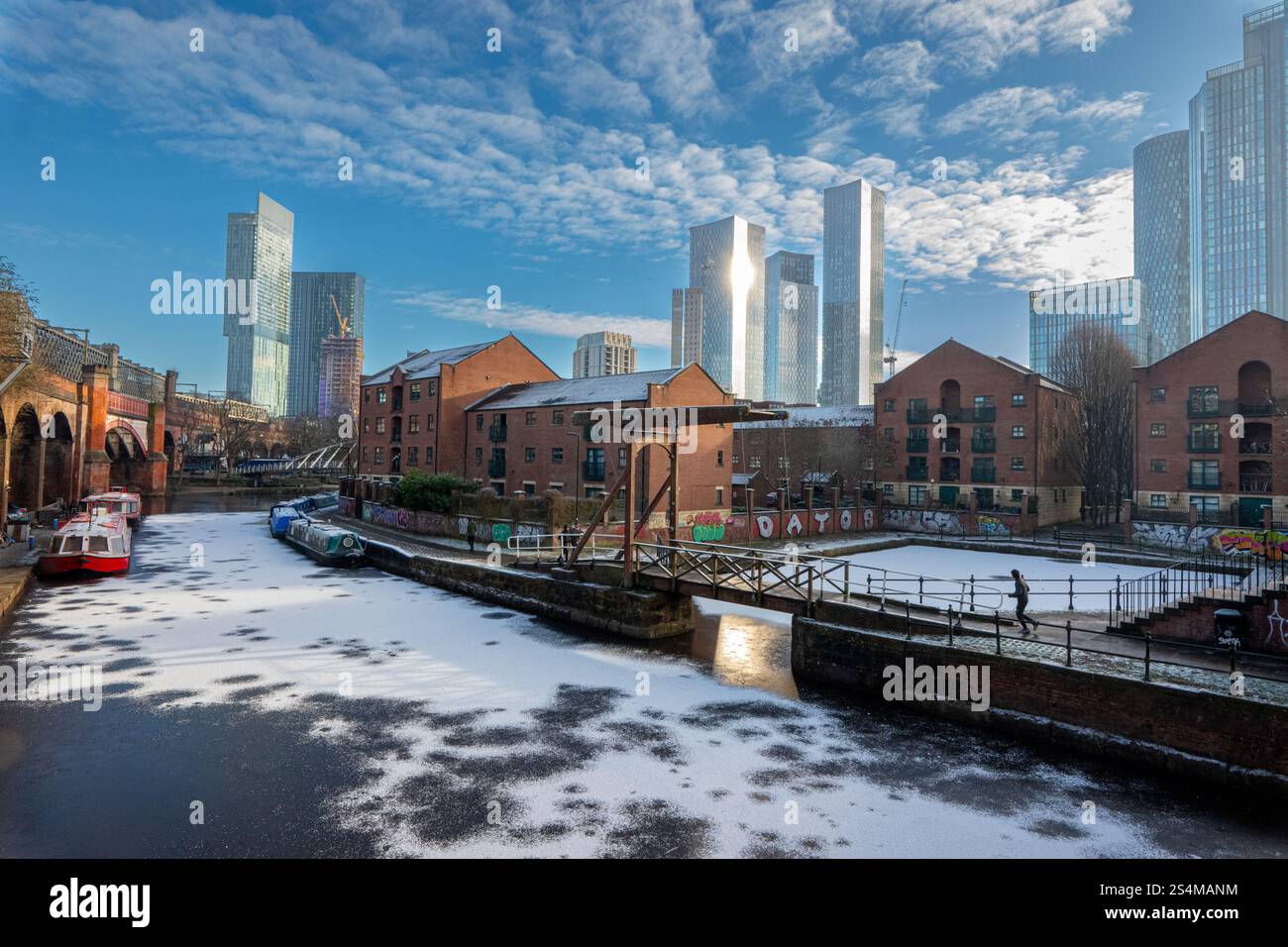 A lone jogger passes frozen Rochdale canal, Castlefield, Manchester.15 ...